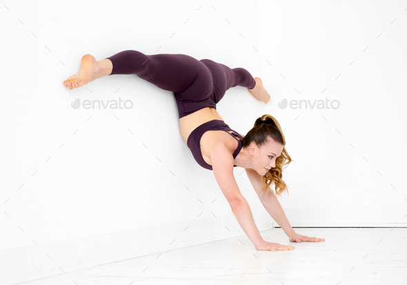 Young gymnast doing a handstand split exercise Stock Photo by Photology75